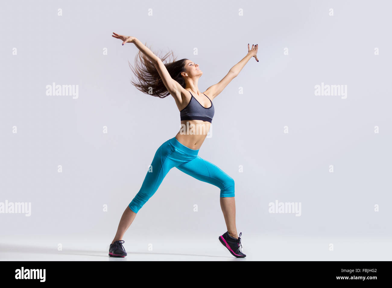 One beautiful young fit modern dancer woman in blue sportswear warming ...