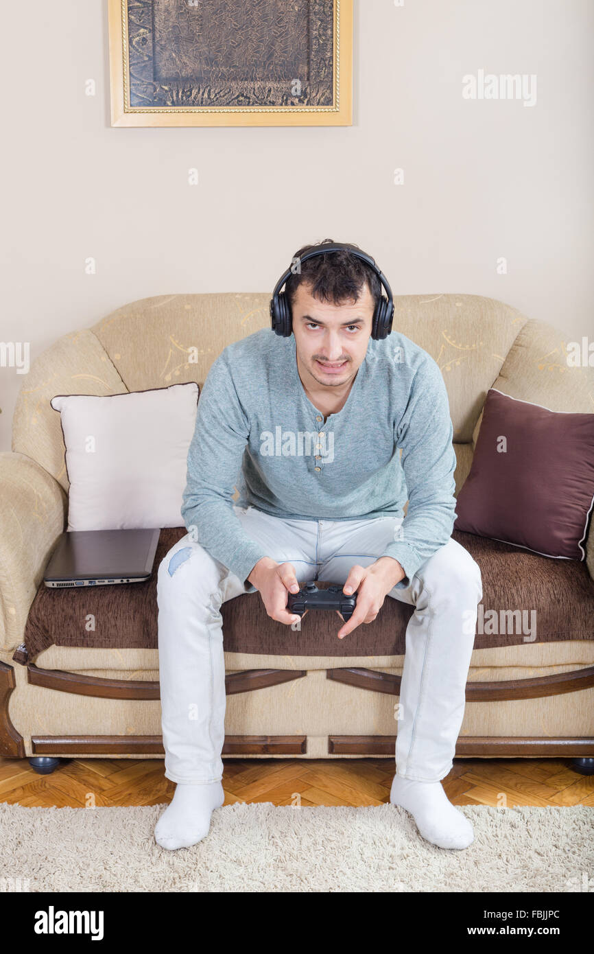 Young man playing video games with wireless Bluetooth joystick in the ...