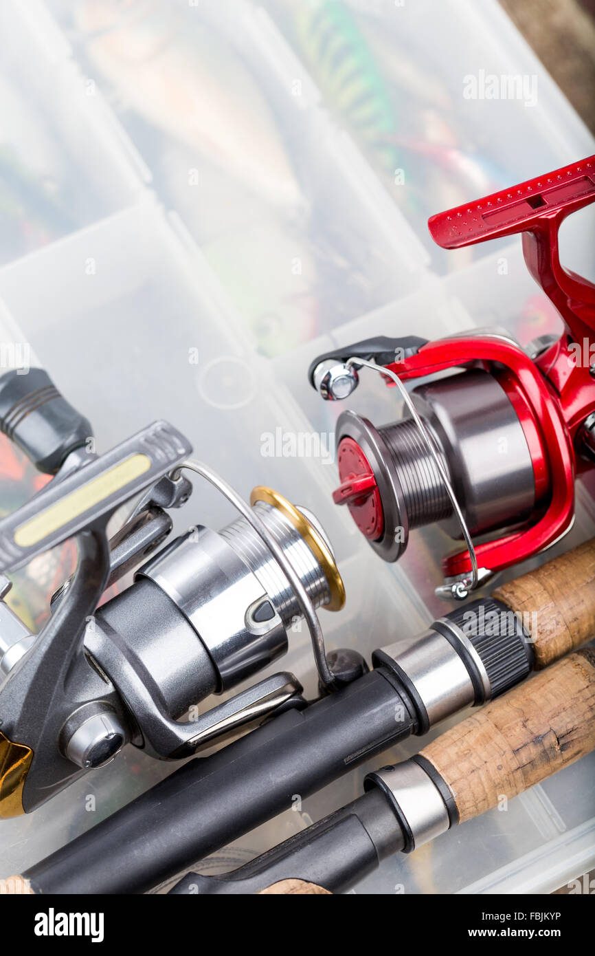 closeup fishing rod with reel on background of tackles in boxes with ...
