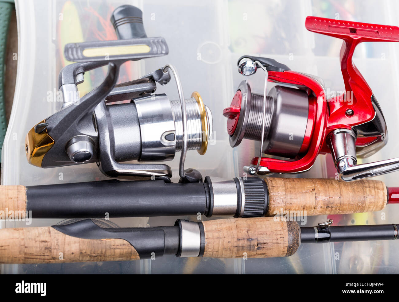 closeup fishing rod with reel on background of tackles in boxes with ...