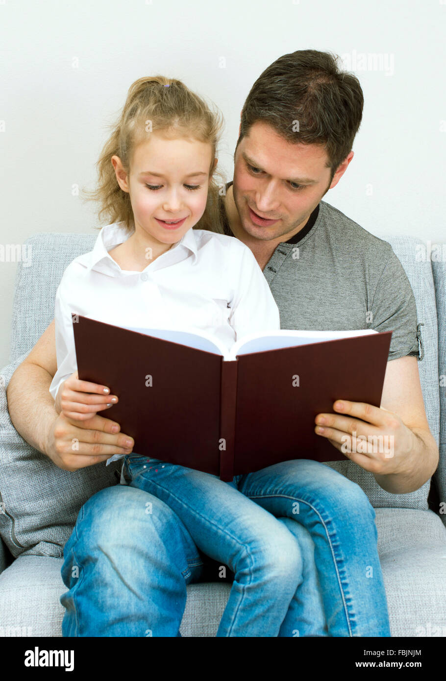 Father reading book with daughter at home Stock Photo - Alamy