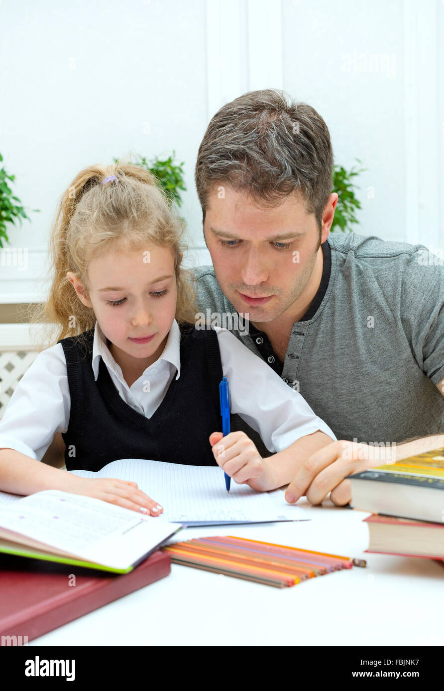 Father helping daughter with homework at home Stock Photo - Alamy