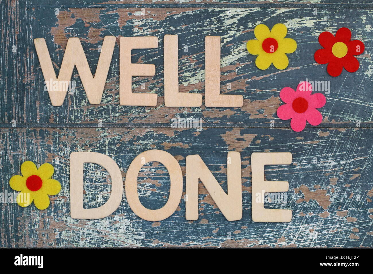 Well done written with wooden letters on rustic surface and colorful ...