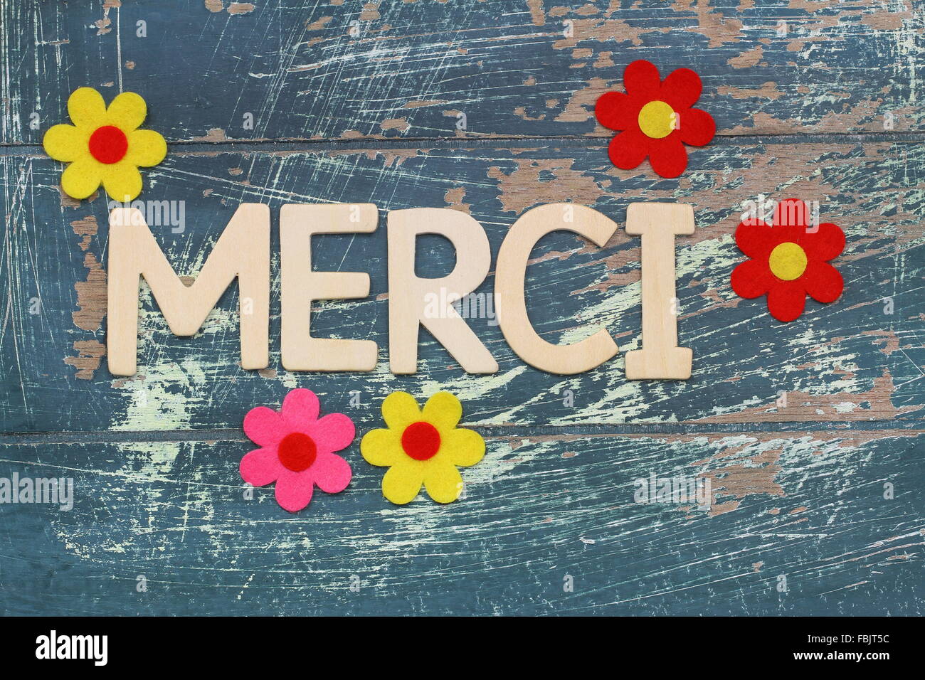 Merci (thank you in French) written with wooden letters on rustic ...