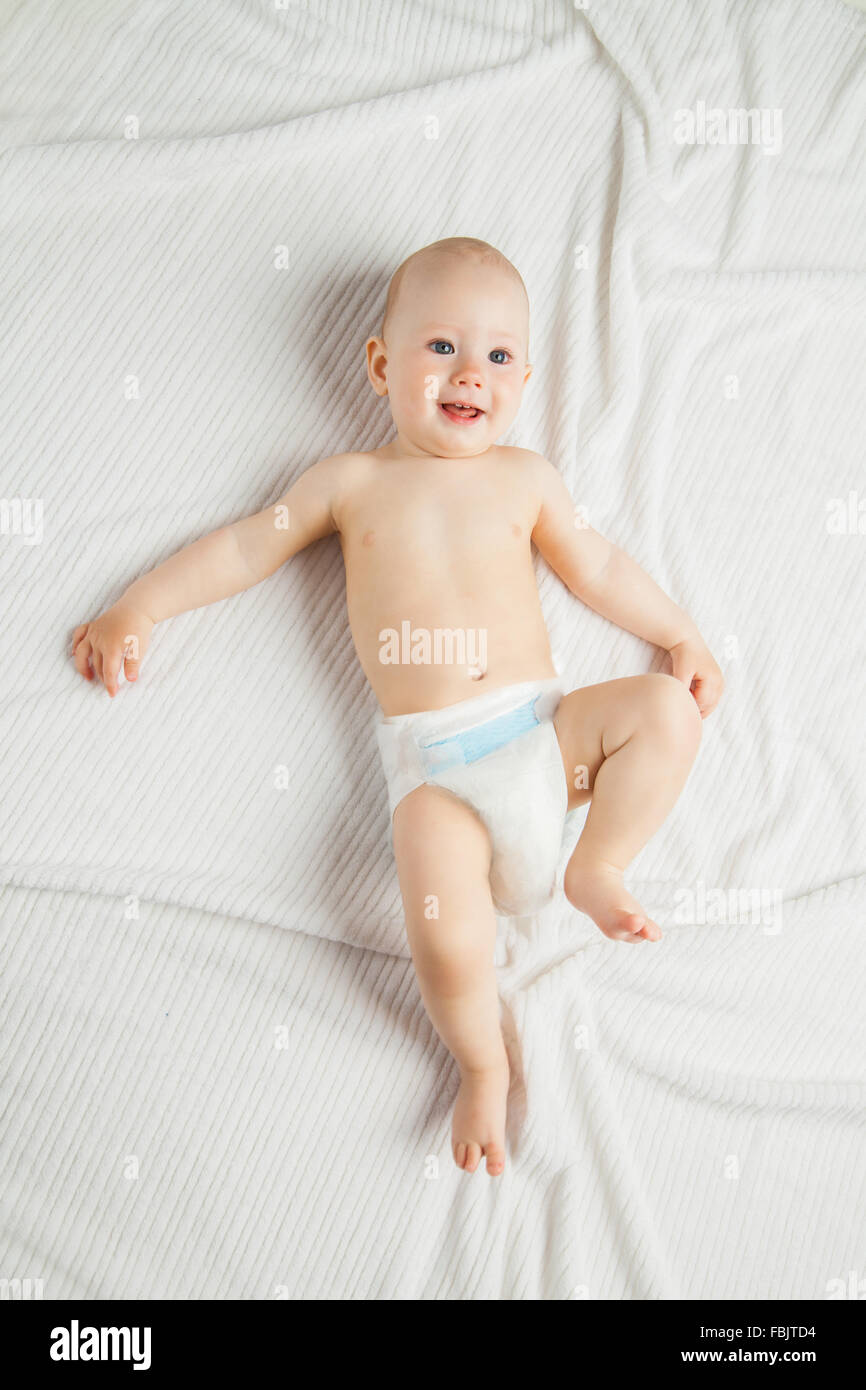 Adorable baby sitting over white background Stock Photo - Alamy