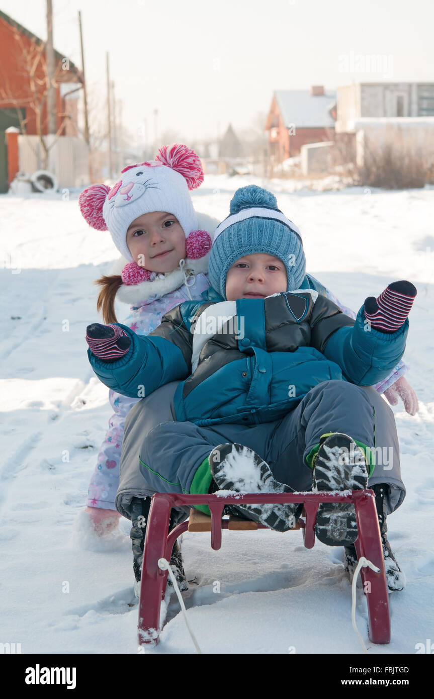 two kids sliding with sledding in the snow Stock Photo - Alamy