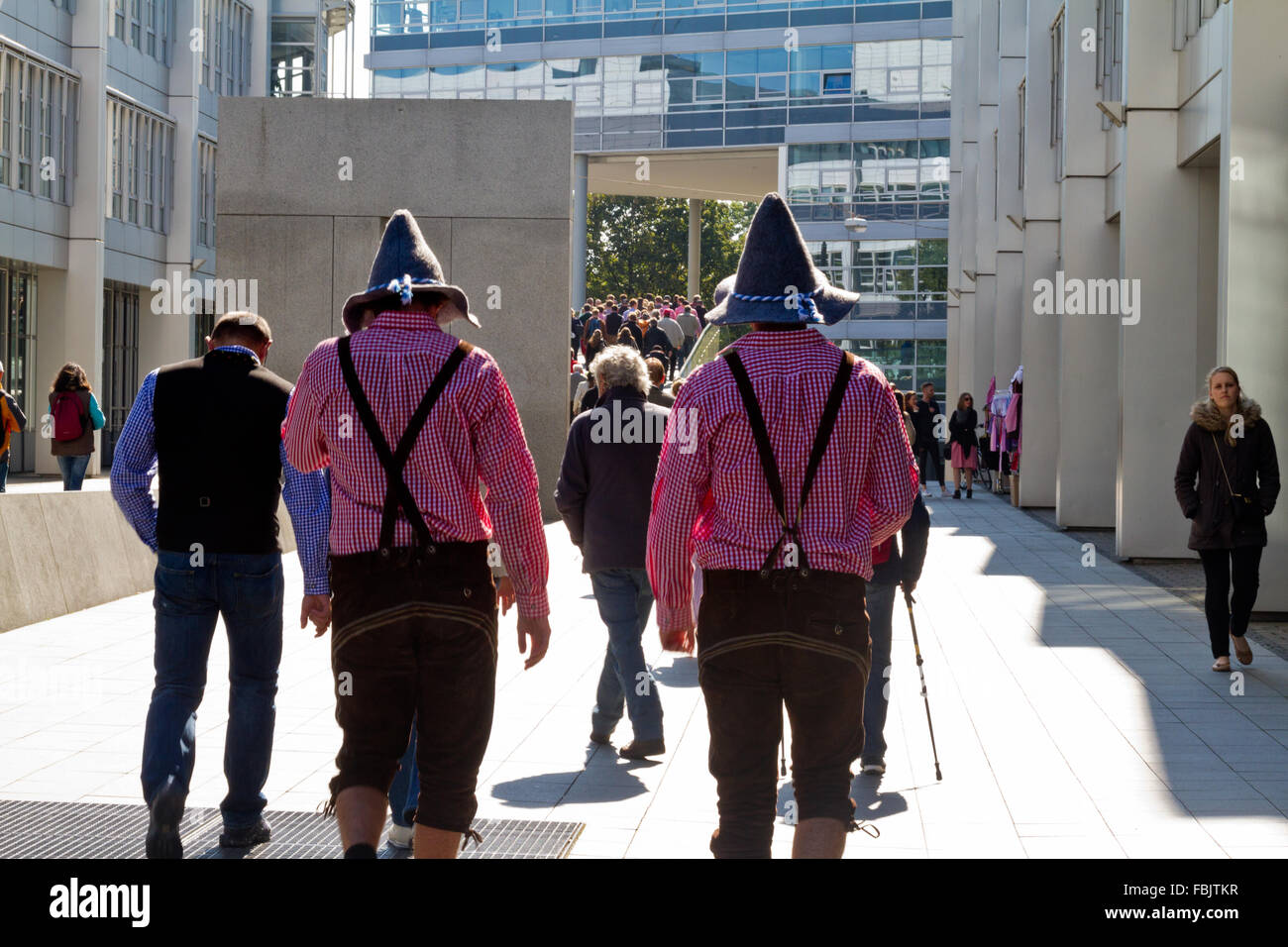 Two men in traditional, identical costumes, wearing jodel hats seen ...