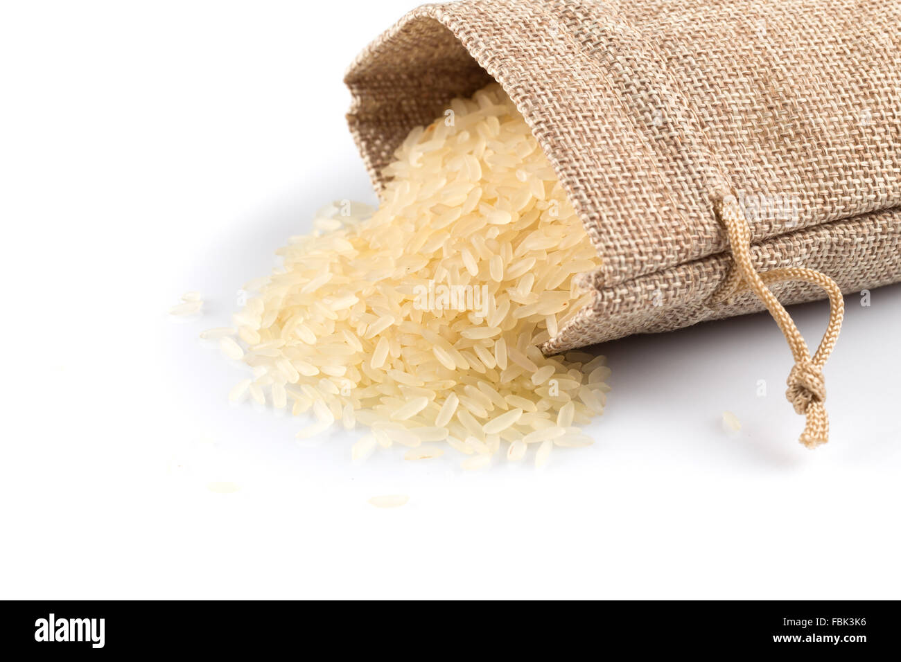 Rice in a sack and spilled on a white background Stock Photo - Alamy