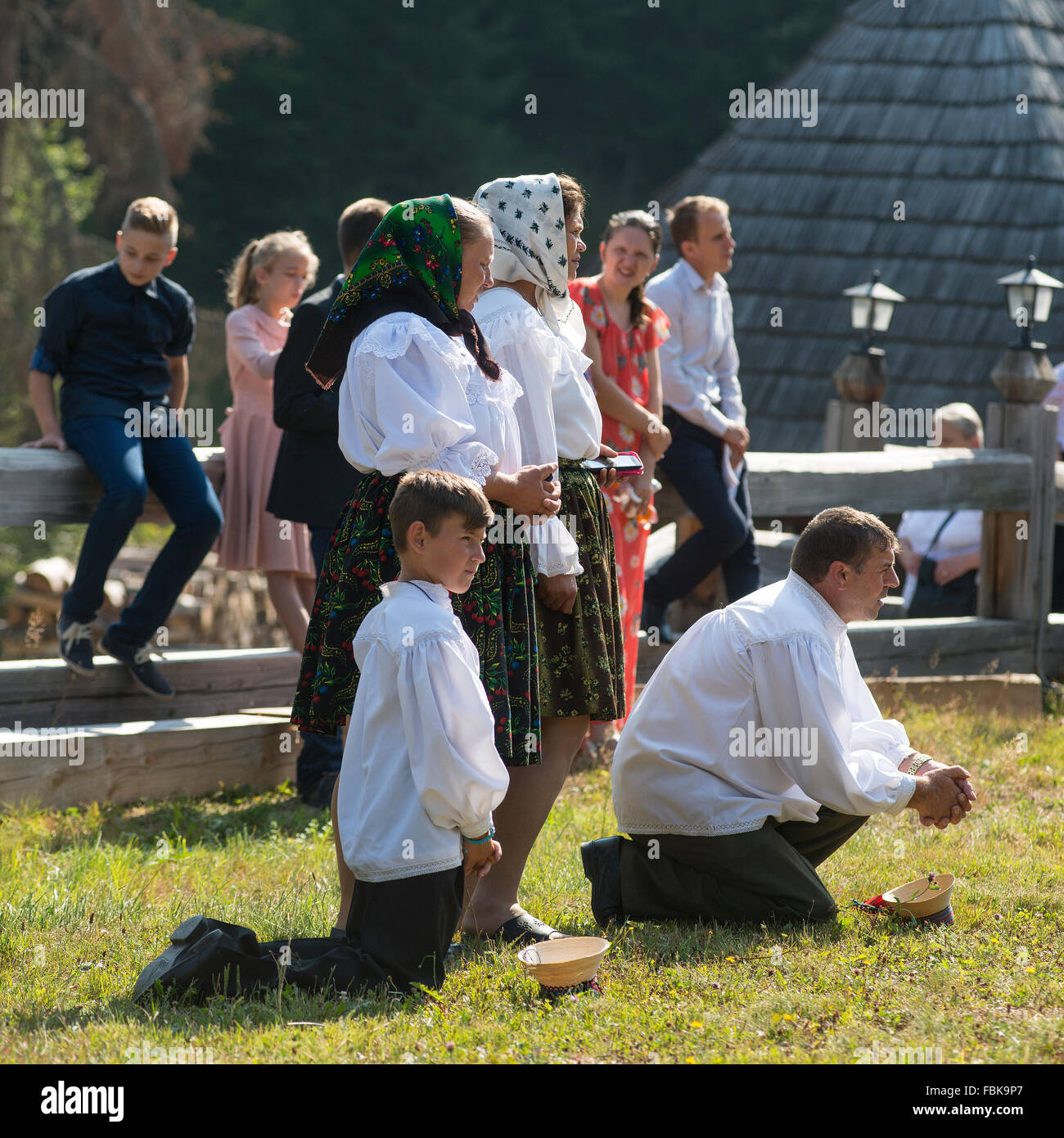 family in traditional costume praying outdoors in the district of ...