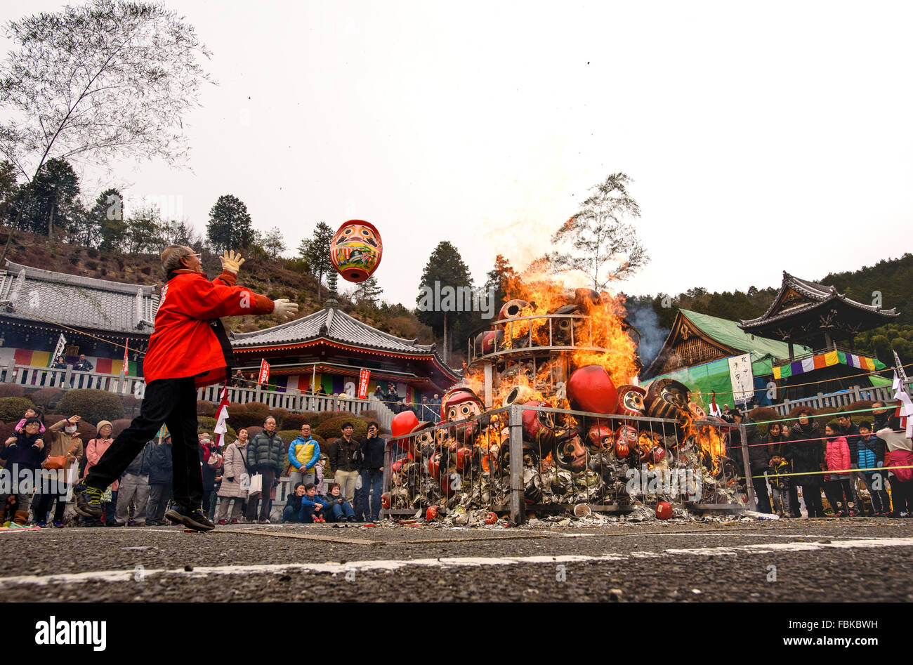 Gifu, Japan. 17th Jan, 2016. A man throws a Daruma doll into the fire ...