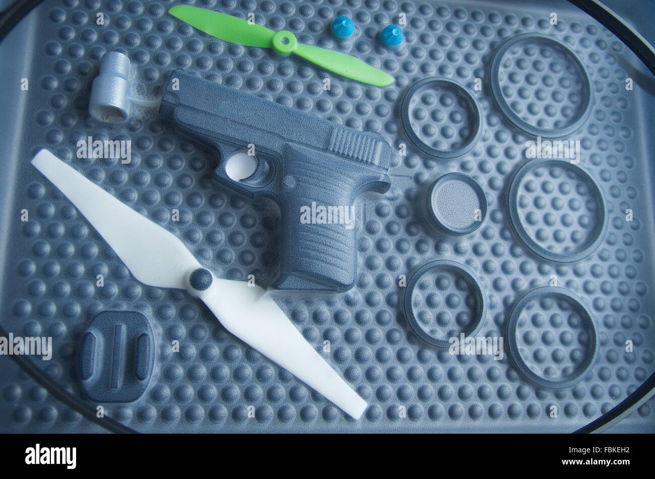 Black rubber rings, toy gun and small propellers lying on plastic ...