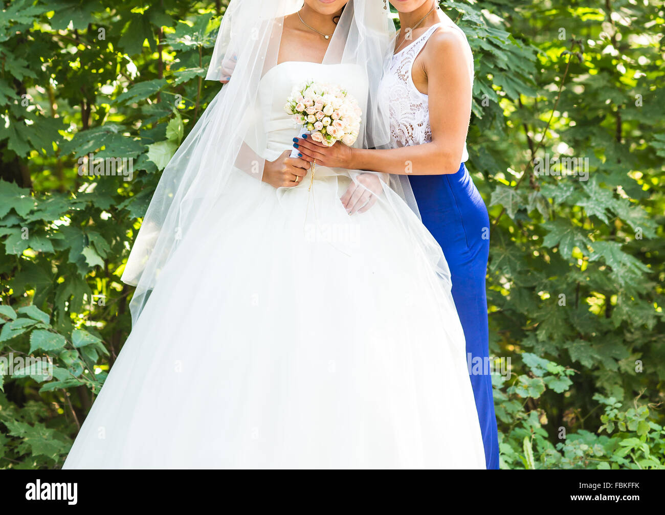 bride and bridesmaid outside happy hug Stock Photo - Alamy