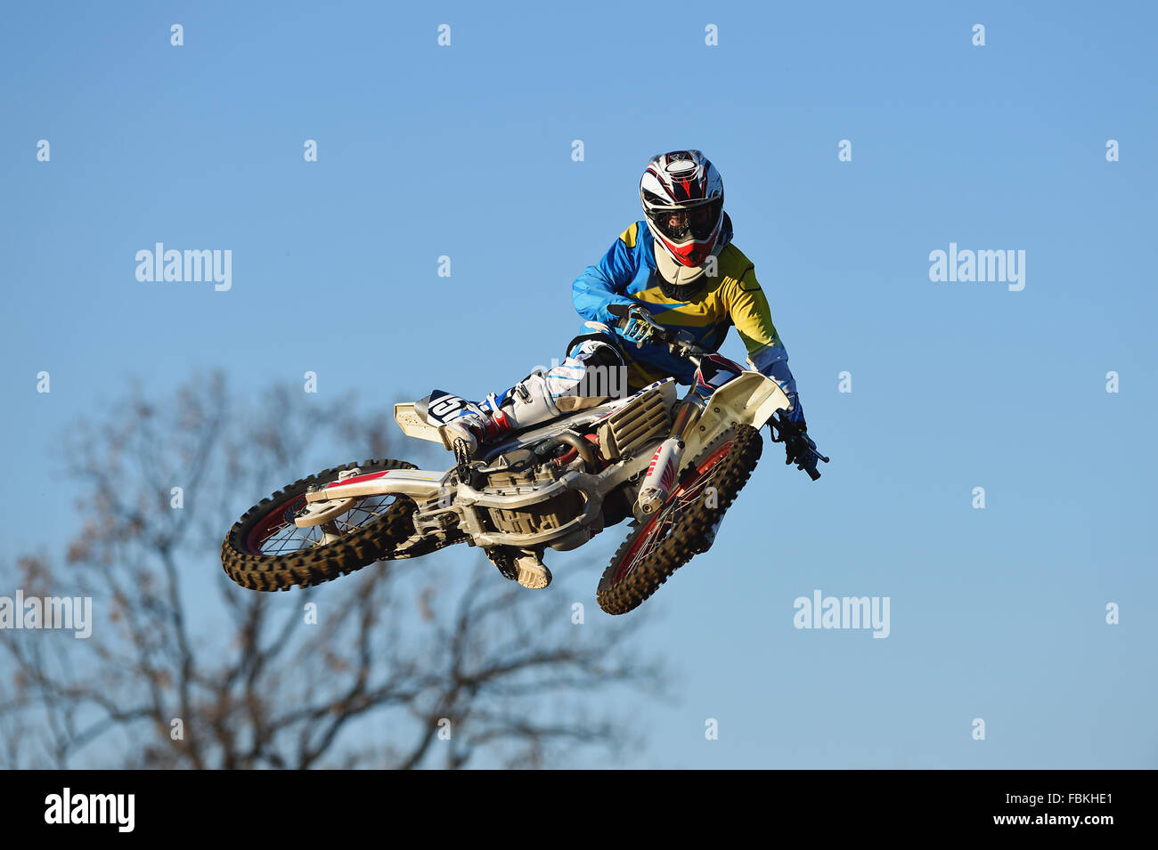 Motocross biker jumping over dirt track Stock Photo - Alamy