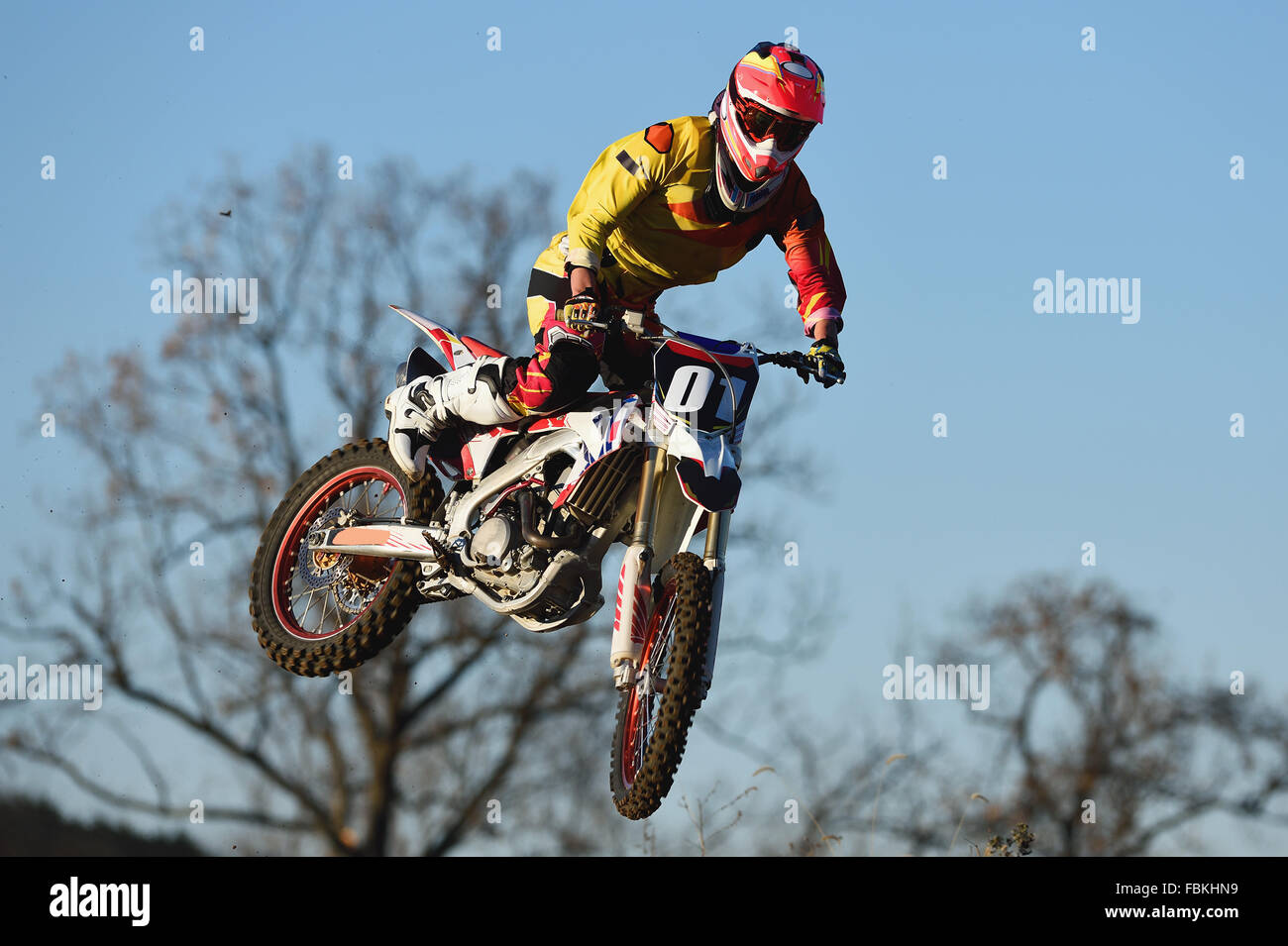 Motocross biker jumping over dirt track Stock Photo - Alamy