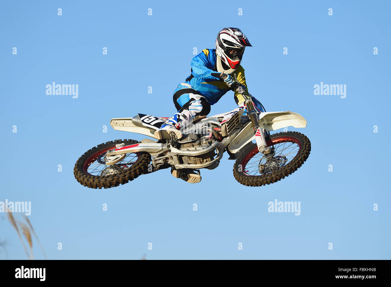 Motocross biker jumping over dirt track Stock Photo - Alamy