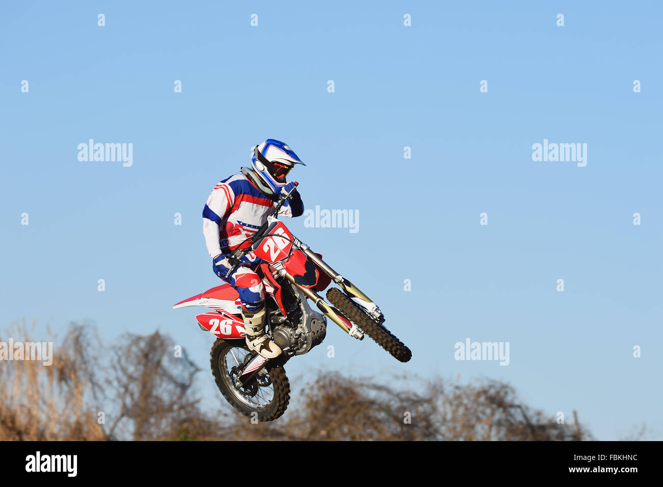 Motocross biker jumping over dirt track Stock Photo - Alamy