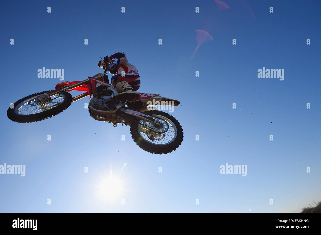 Motocross biker jumping over dirt track Stock Photo - Alamy