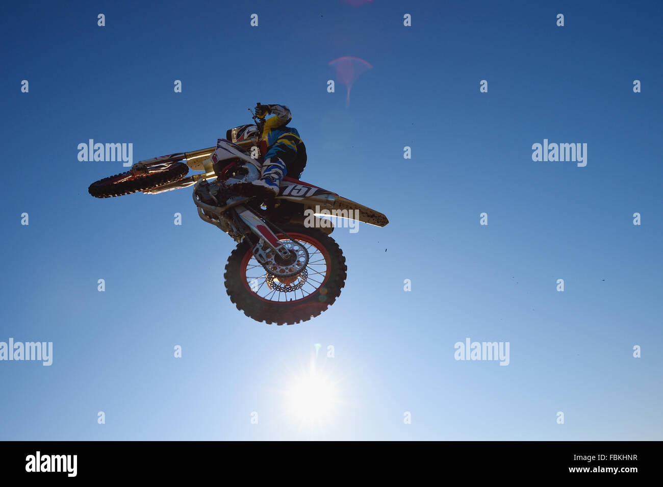 Motocross biker jumping over dirt track Stock Photo - Alamy