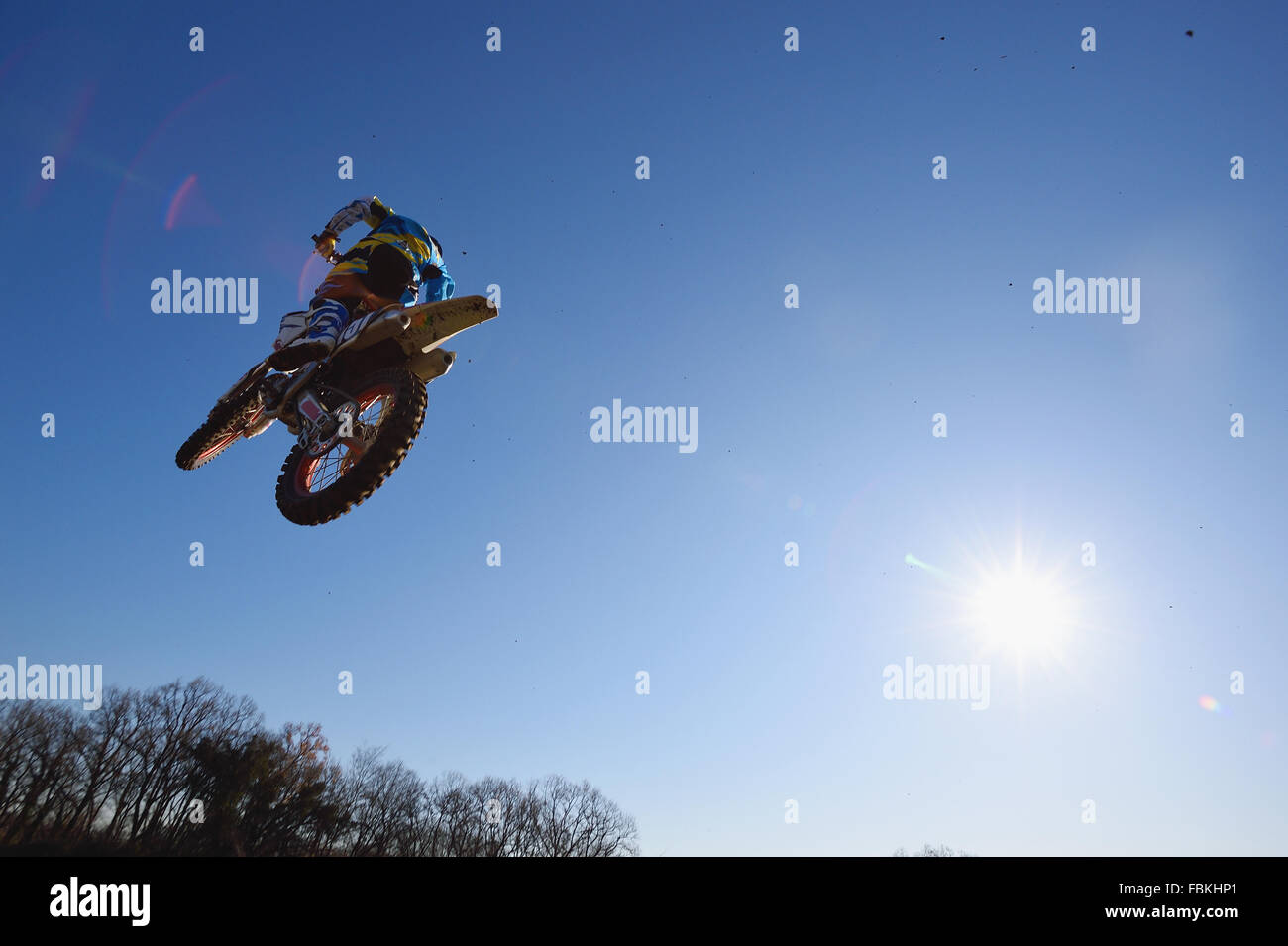Motocross biker jumping over dirt track Stock Photo - Alamy