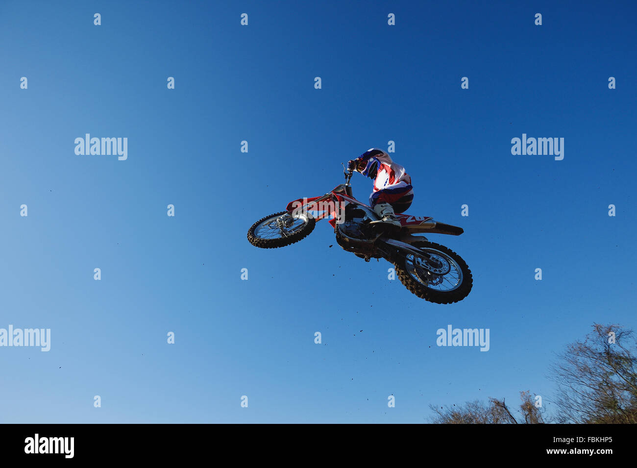 Motocross biker jumping over dirt track Stock Photo - Alamy