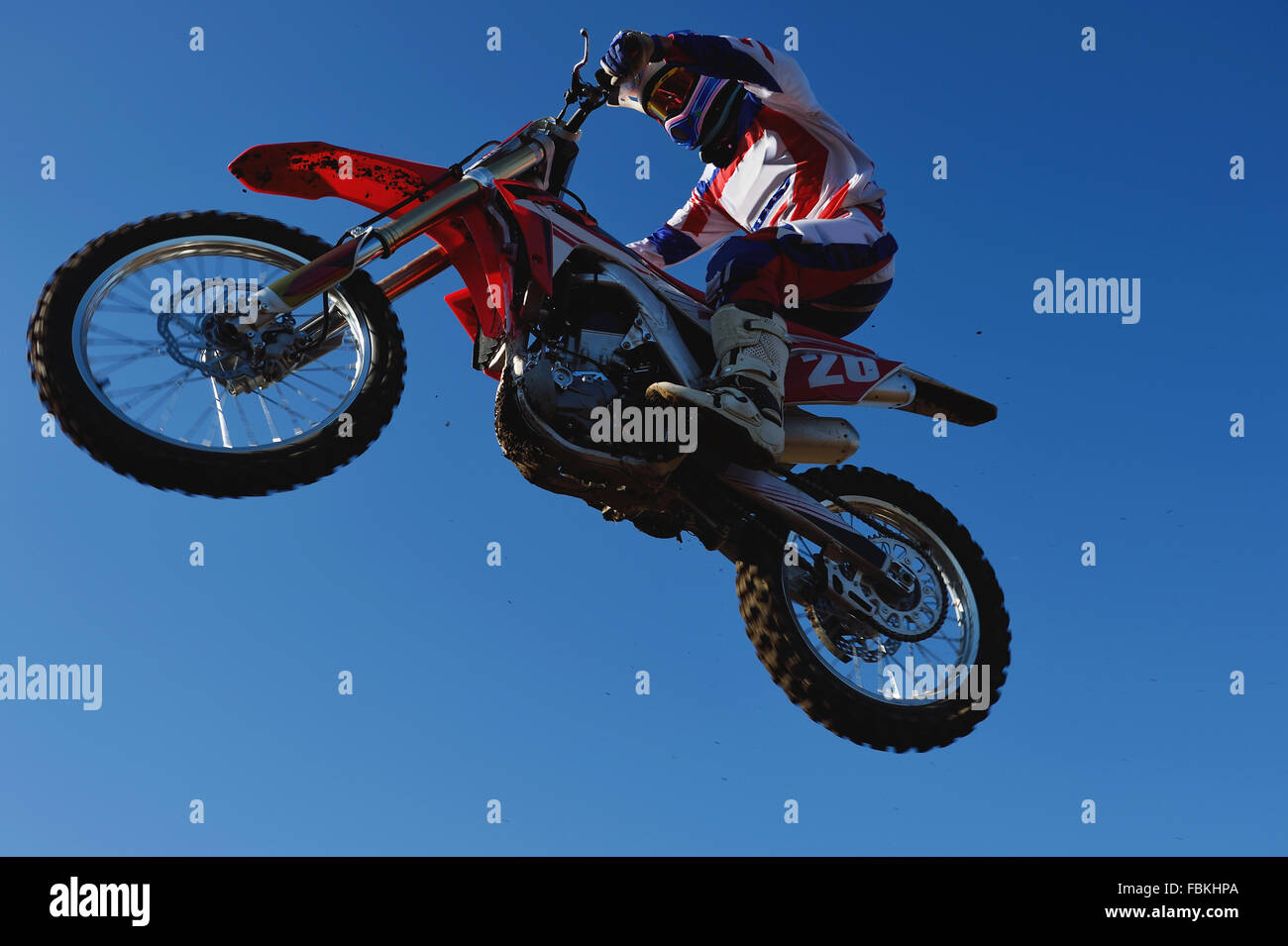 Motocross biker jumping over dirt track Stock Photo - Alamy
