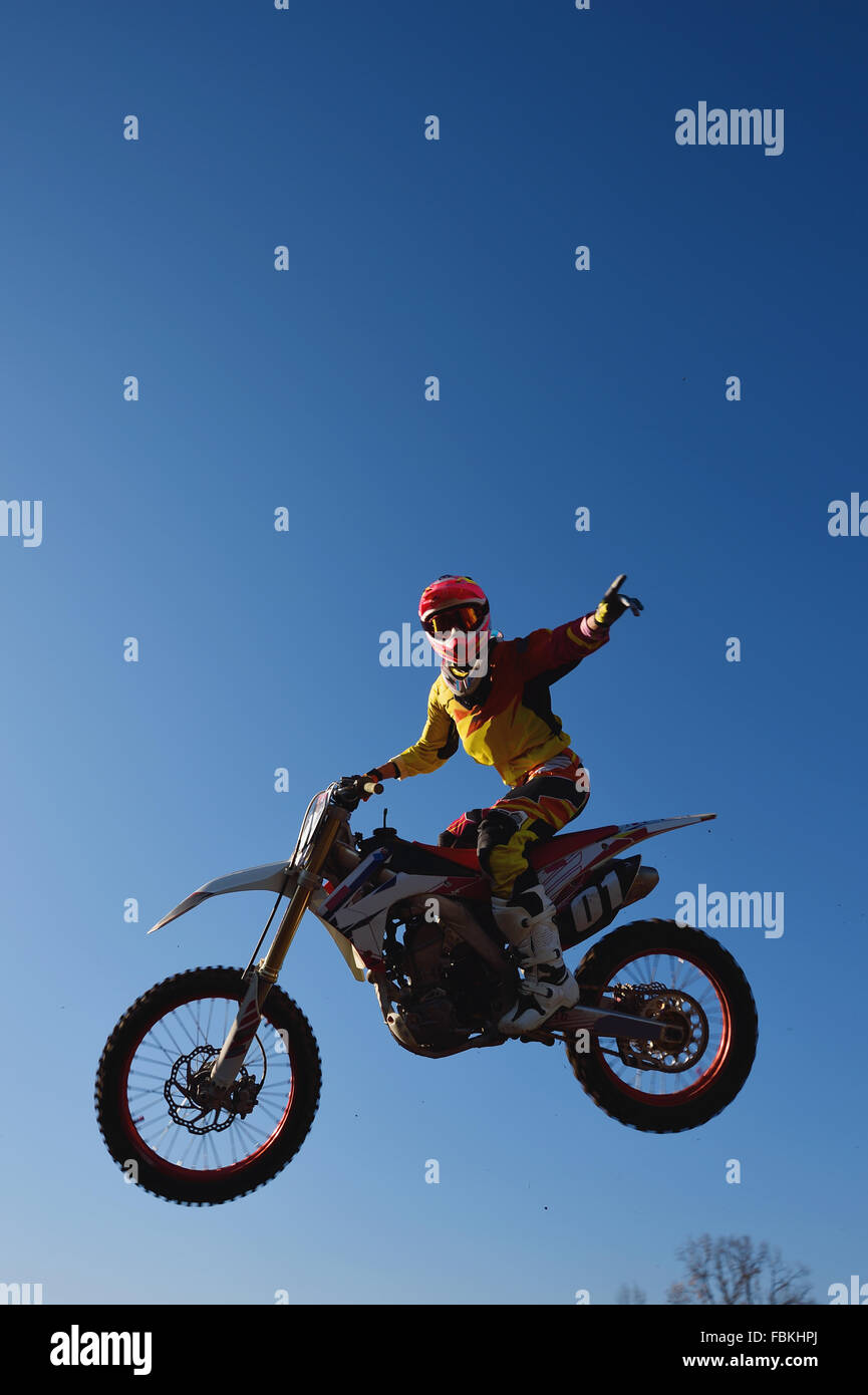 Motocross biker jumping over dirt track Stock Photo - Alamy