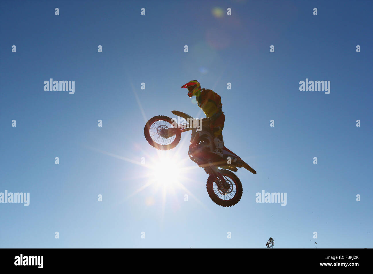 Motocross biker jumping over dirt track Stock Photo - Alamy