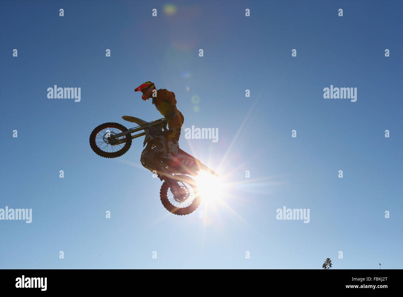 Motocross biker jumping over dirt track Stock Photo - Alamy
