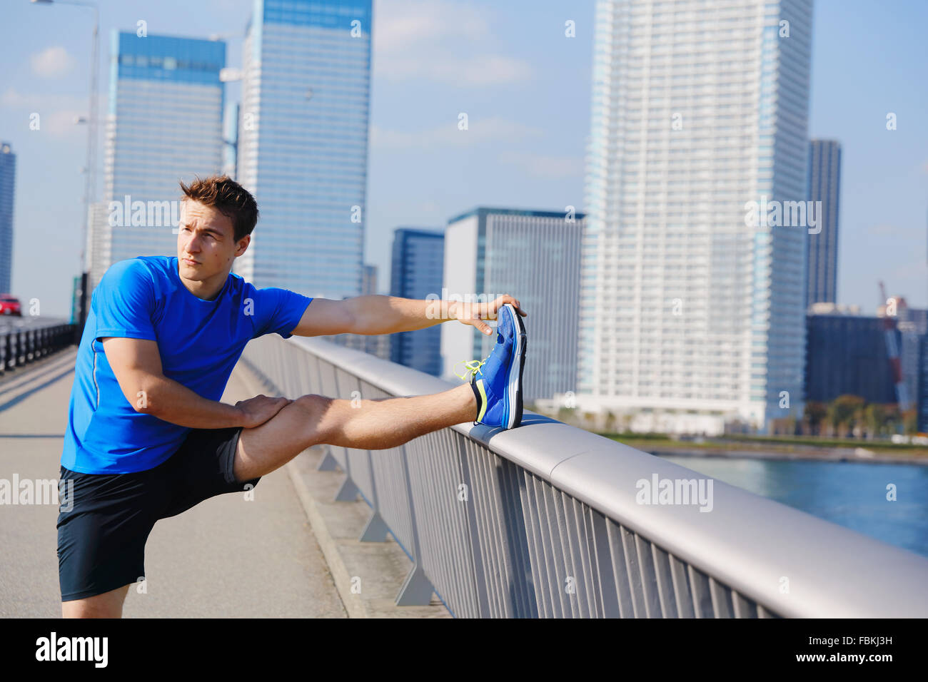 Young Caucasian man stretching in metropolitan area Stock Photo - Alamy