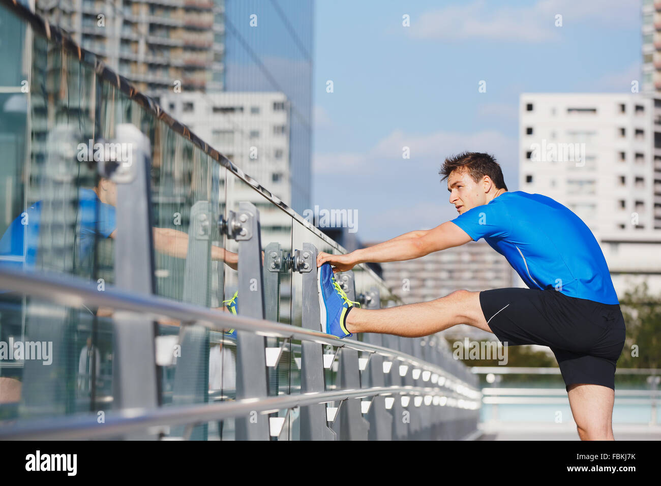 Young Caucasian man stretching in metropolitan area Stock Photo - Alamy