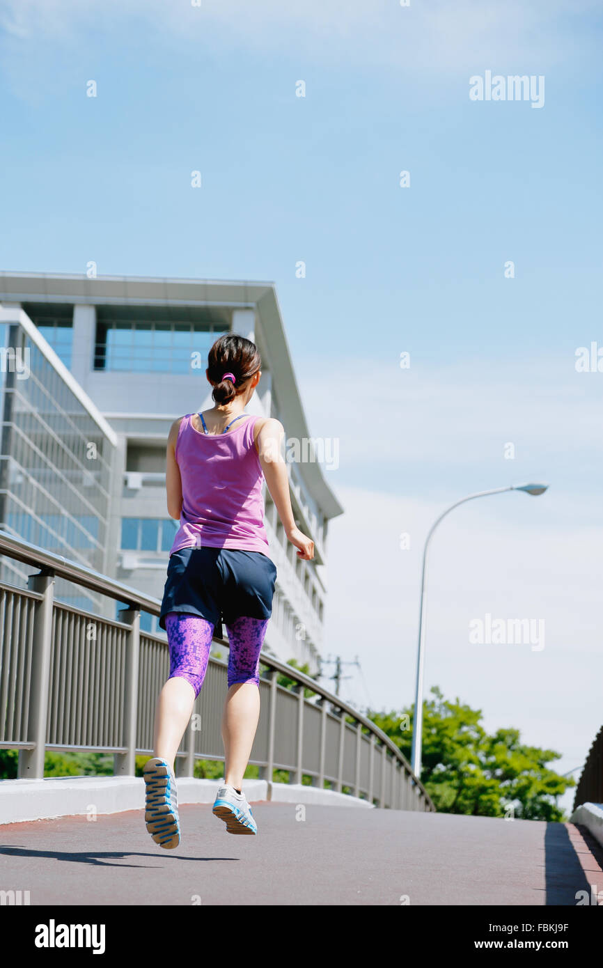 Young Japanese woman running downtown Tokyo Stock Photo - Alamy