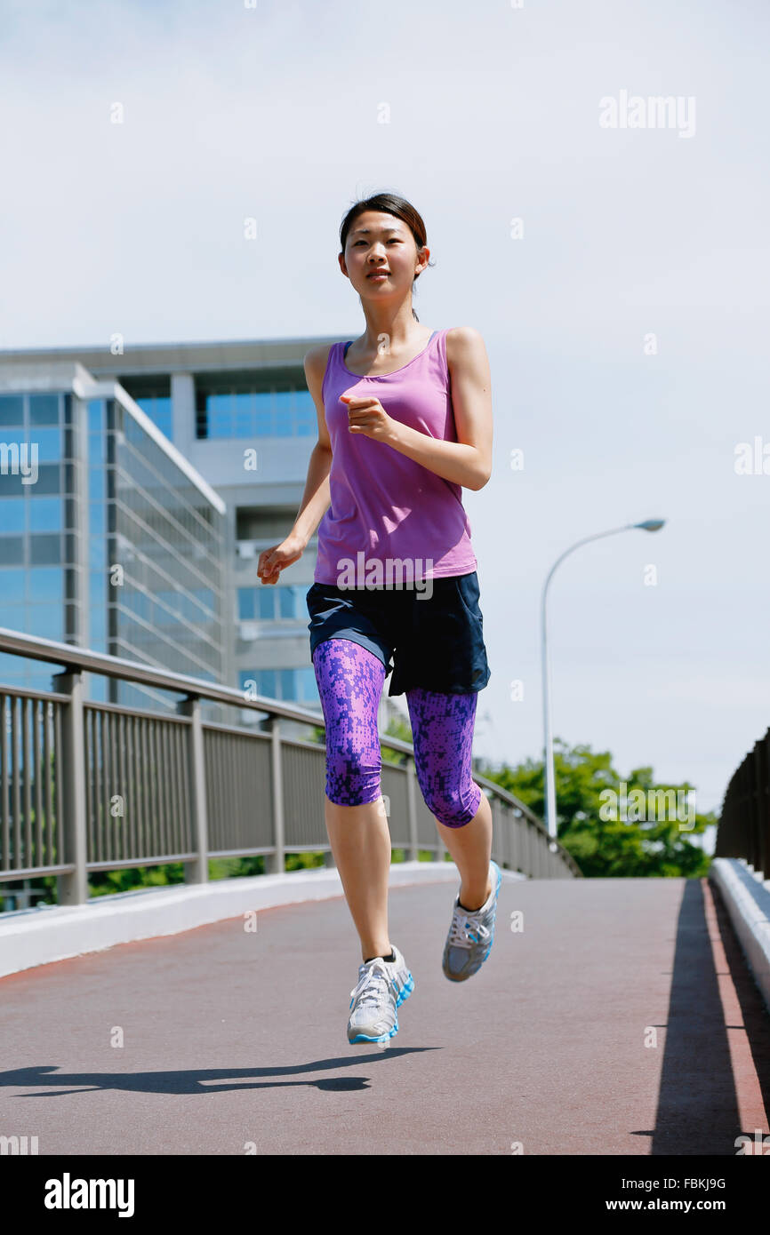 Young Japanese woman running downtown Tokyo Stock Photo - Alamy
