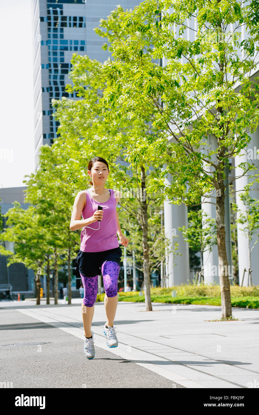 Young Japanese woman running downtown Tokyo Stock Photo - Alamy