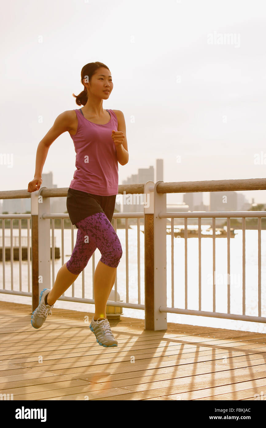 Young Japanese woman running downtown Tokyo Stock Photo - Alamy