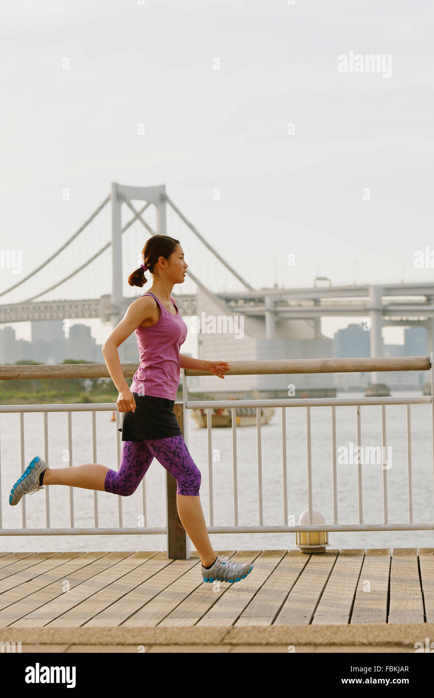 Young Japanese woman running downtown Tokyo Stock Photo - Alamy