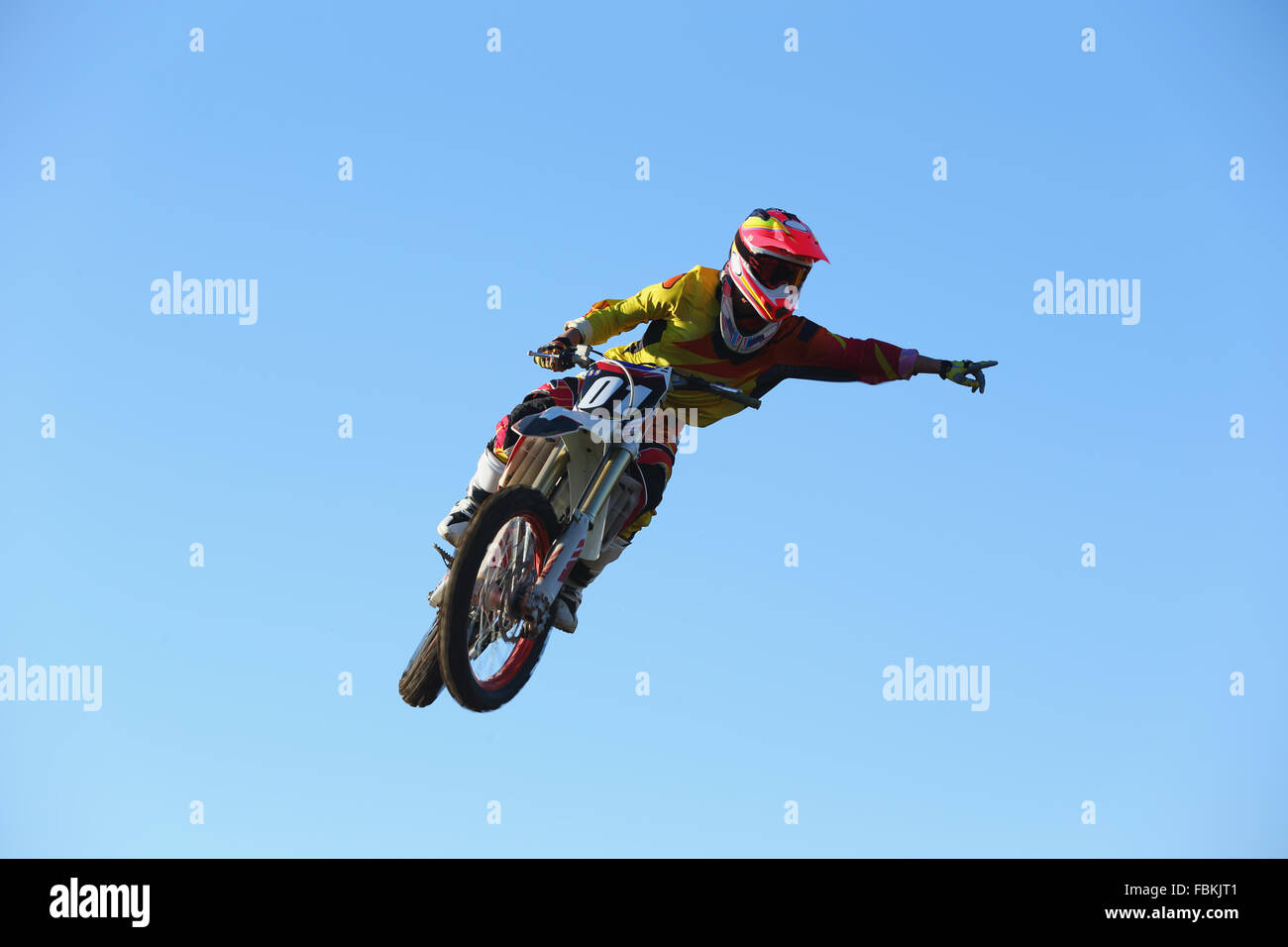 Motocross biker jumping over dirt track Stock Photo - Alamy