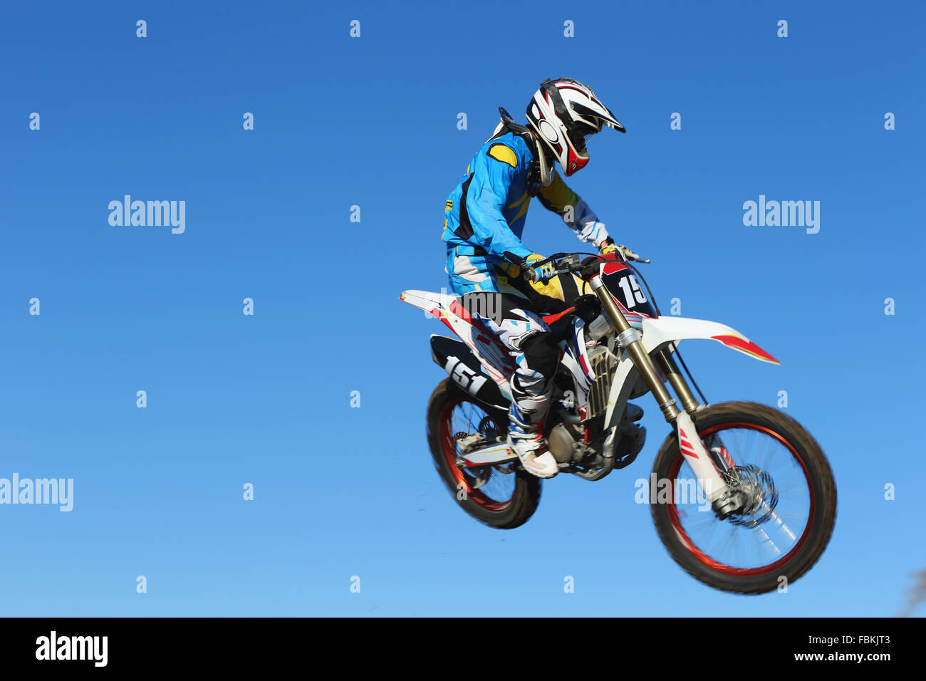 Motocross biker jumping over dirt track Stock Photo - Alamy