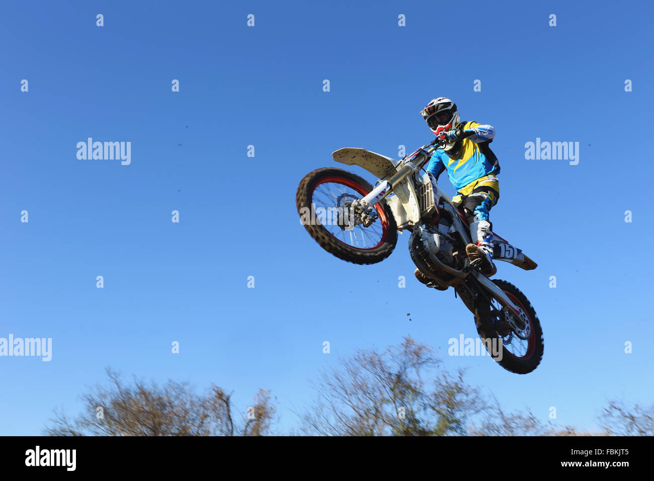 Motocross biker jumping over dirt track Stock Photo - Alamy