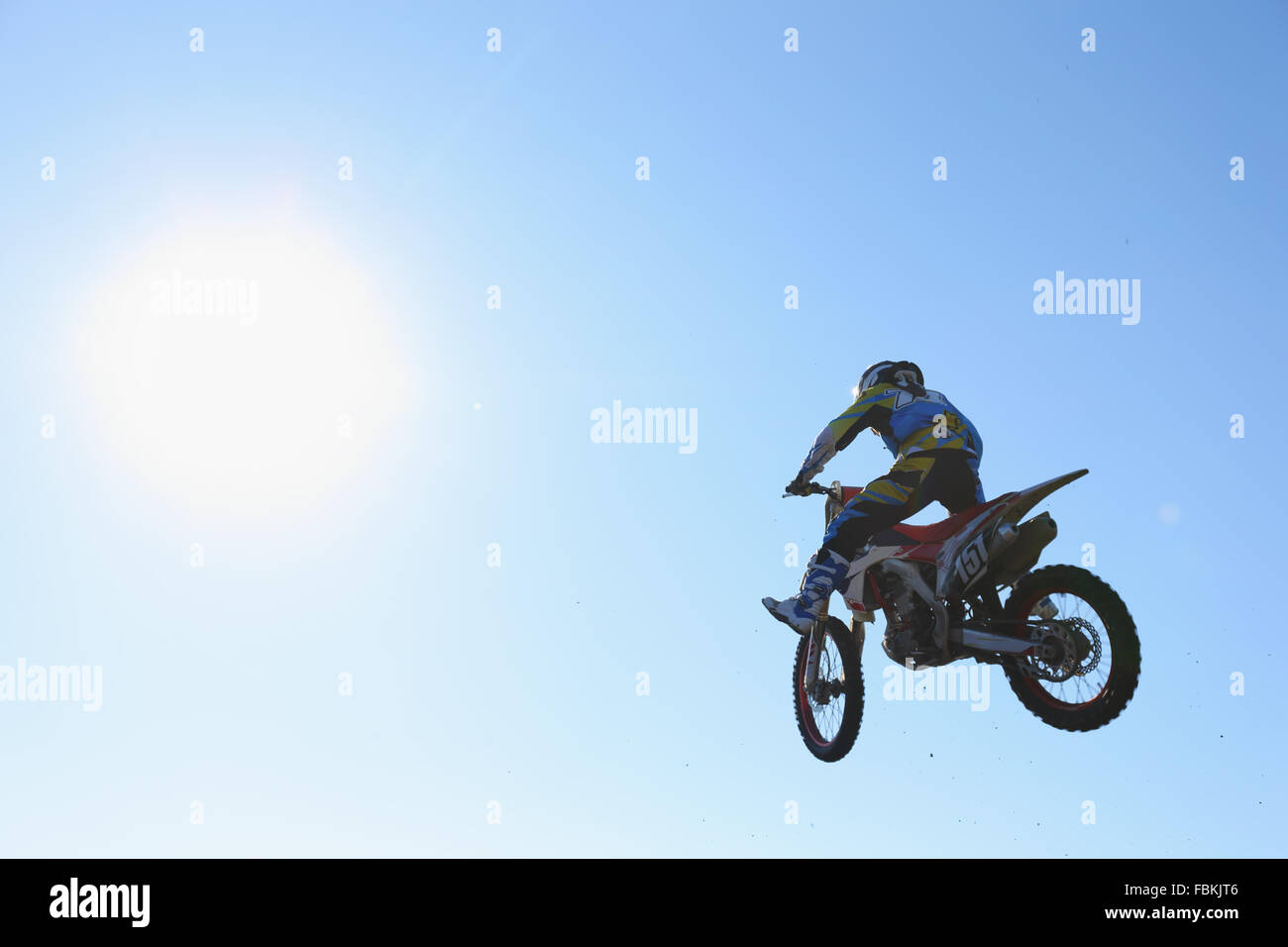 Motocross biker jumping over dirt track Stock Photo - Alamy