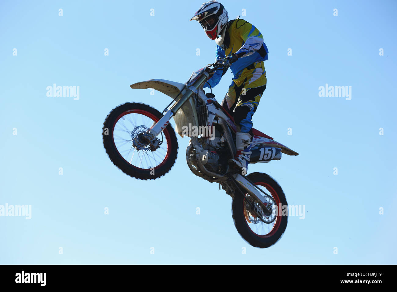 Motocross biker jumping over dirt track Stock Photo - Alamy