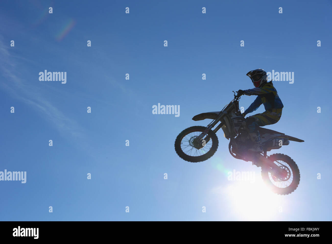 Motocross biker jumping over dirt track Stock Photo - Alamy