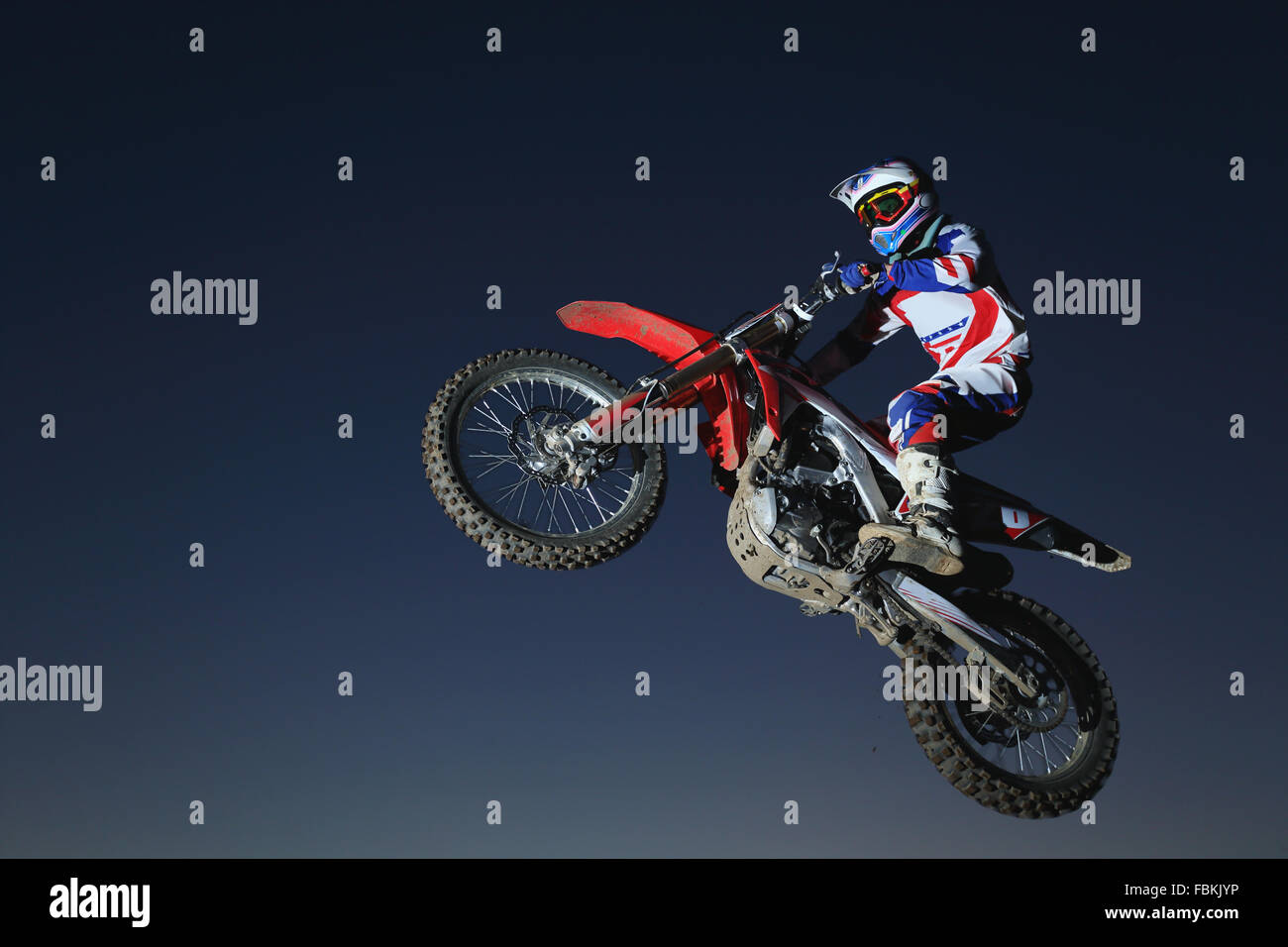 Motocross biker jumping over dirt track Stock Photo - Alamy