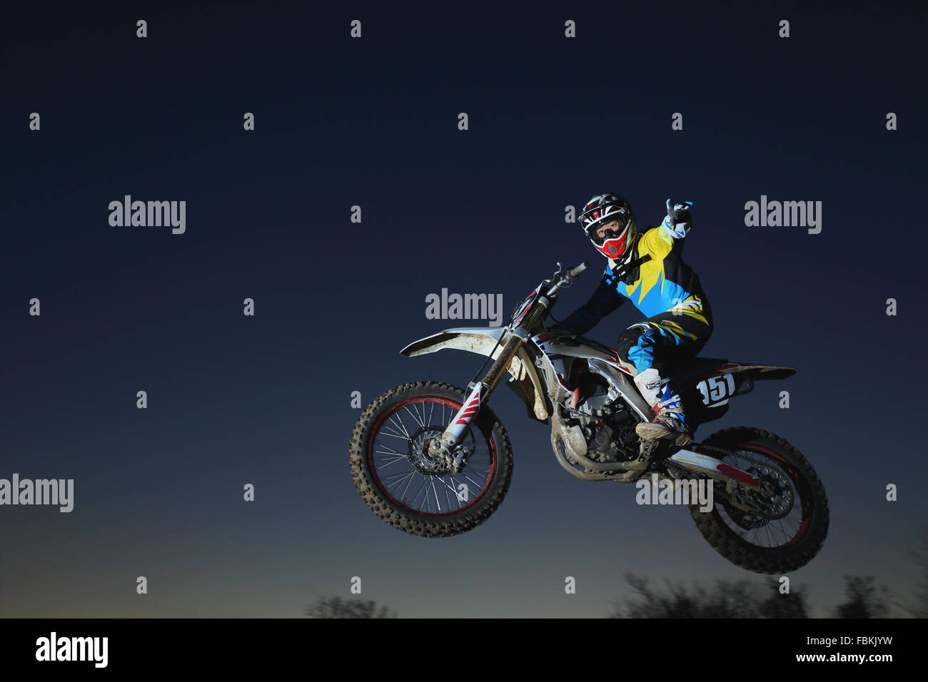 Motocross biker jumping over dirt track Stock Photo - Alamy