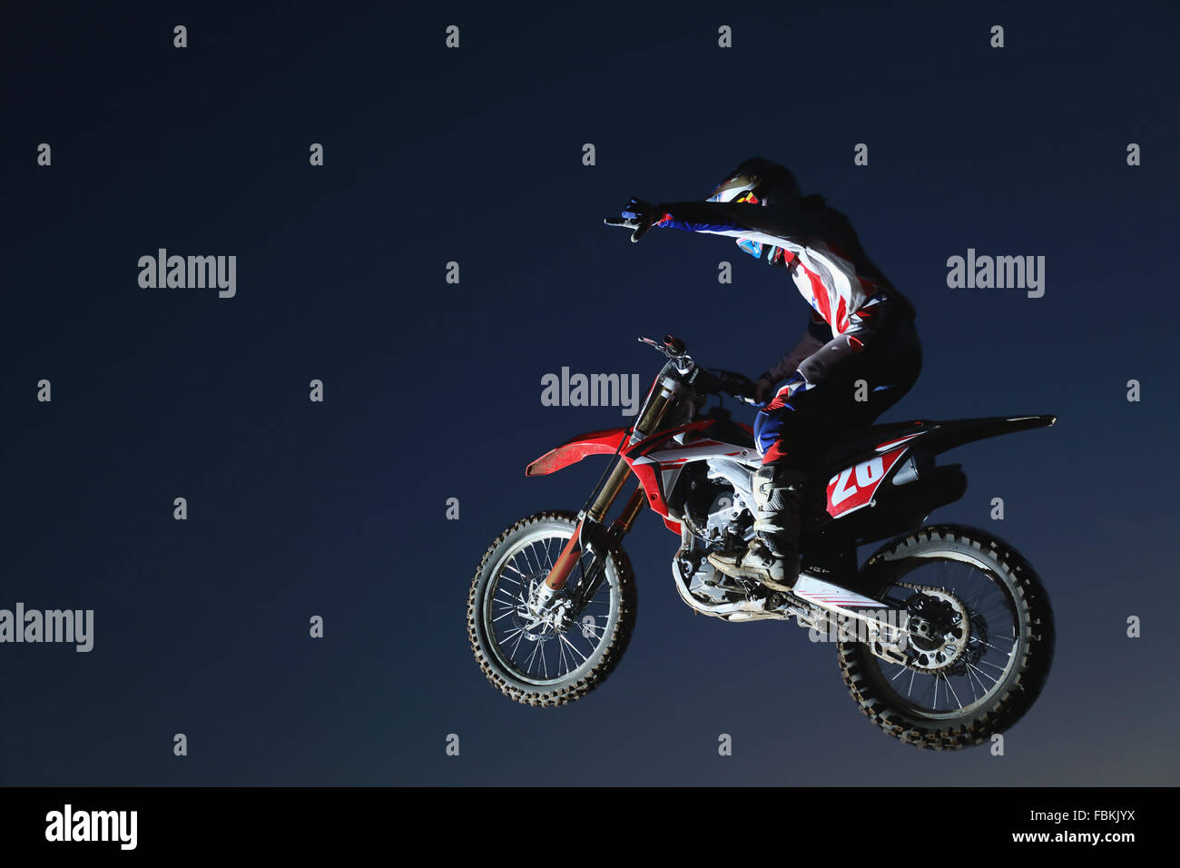 Motocross biker jumping over dirt track Stock Photo - Alamy