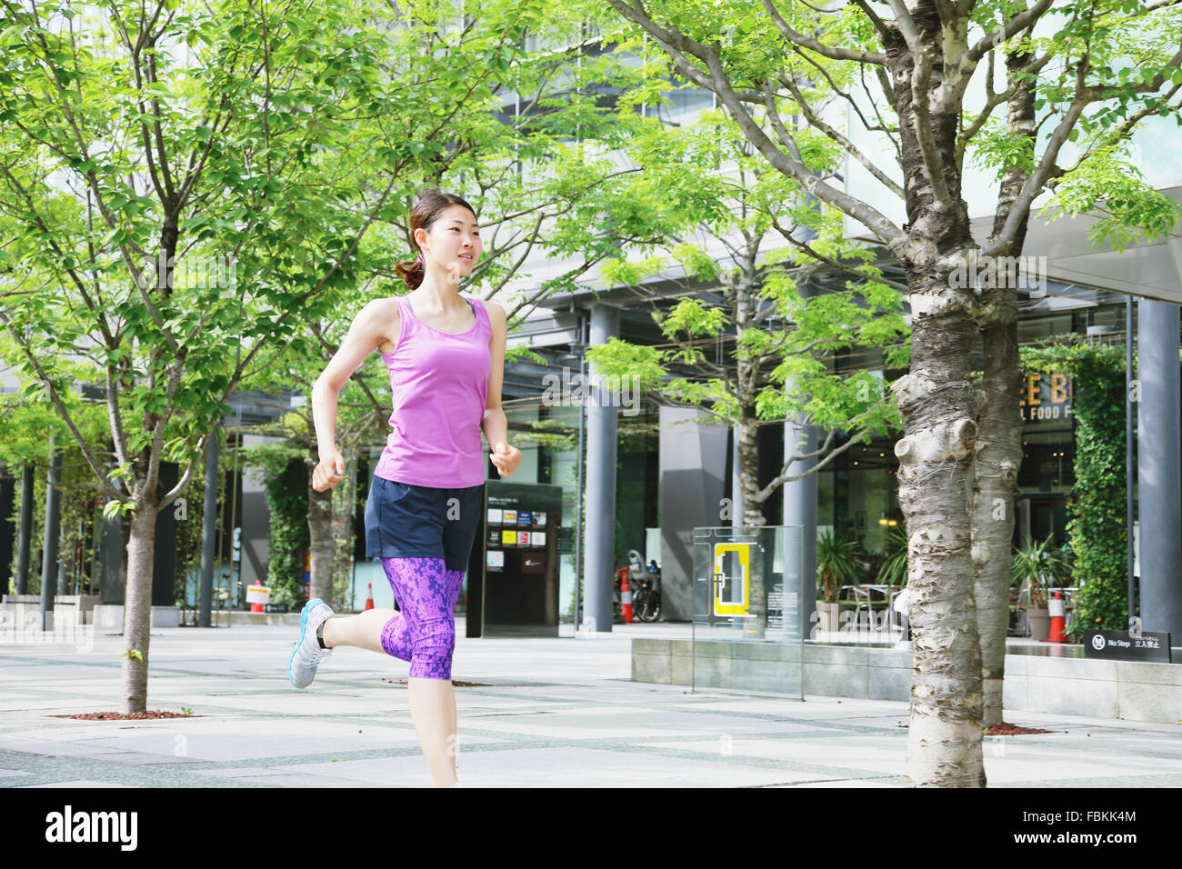 Young Japanese woman running downtown Tokyo Stock Photo - Alamy