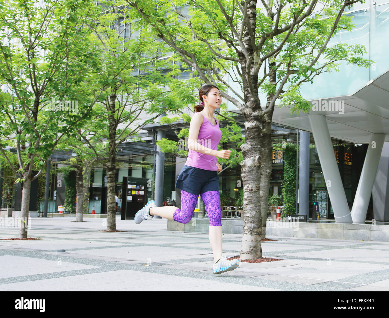 Young Japanese woman running downtown Tokyo Stock Photo - Alamy