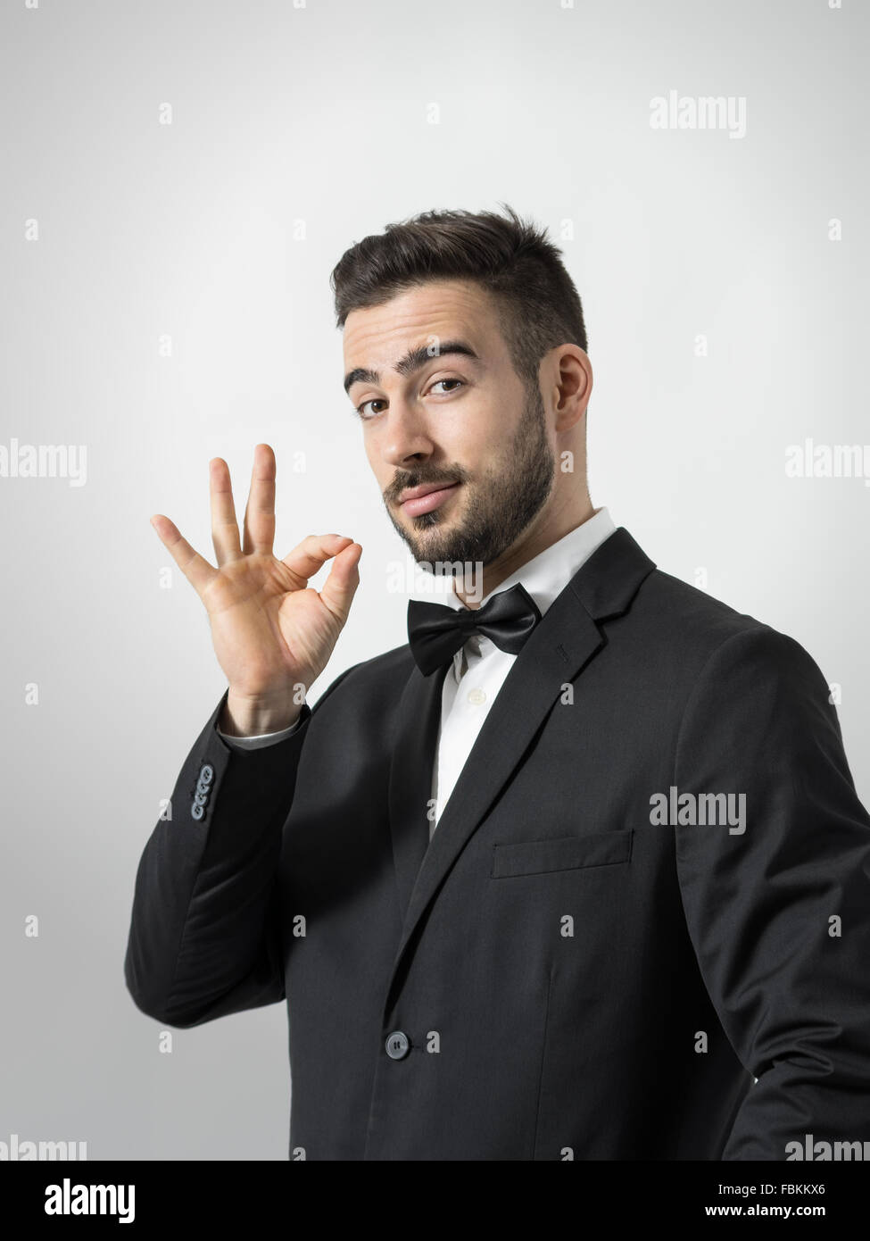 Young bearded restaurant waiter showing delicious hand gesture looking ...