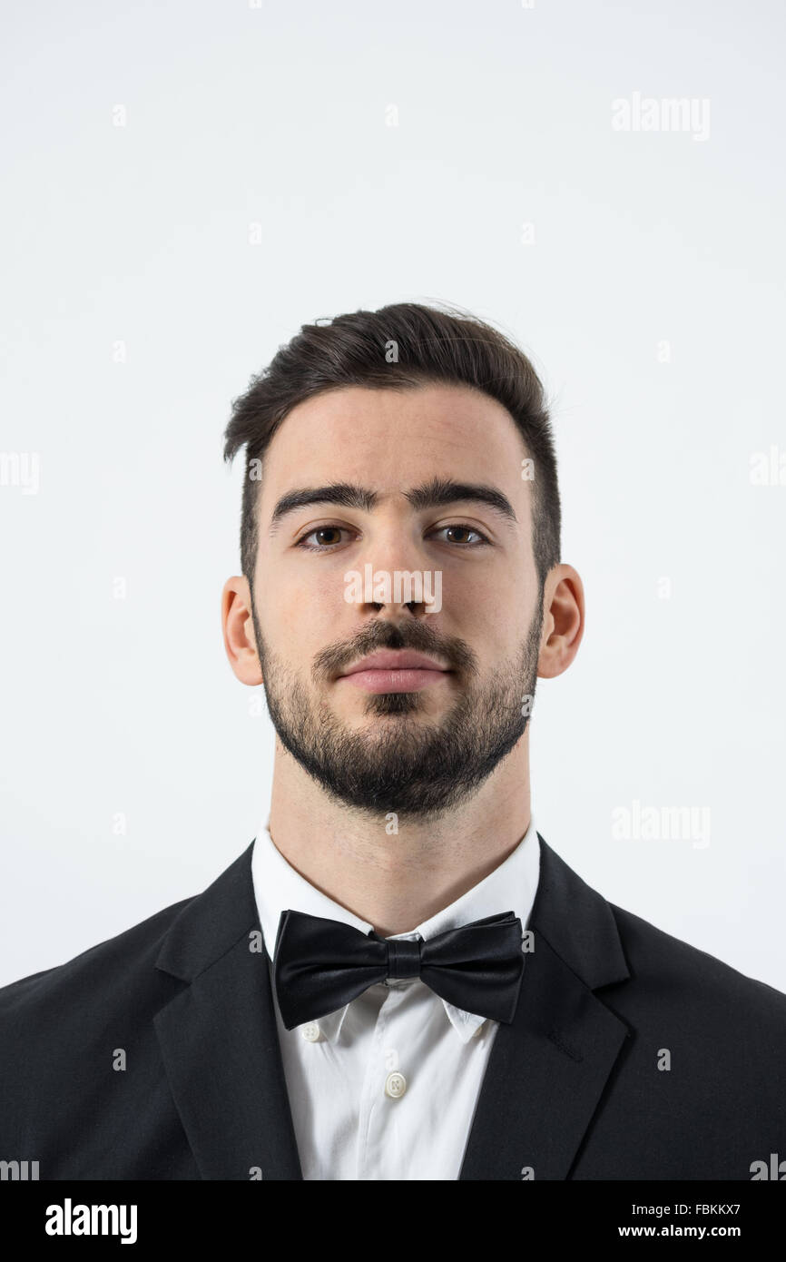 Close up portrait of young man with head leaned back in tuxedo with bow ...