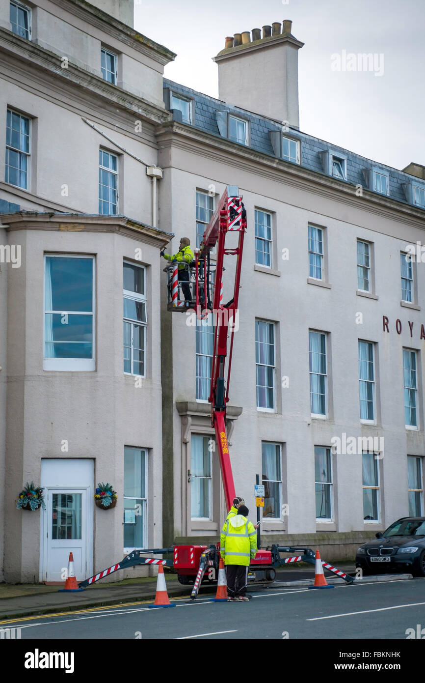 Workman repairing a roof on the Royal Hotel Whitby using a hydraulic ...