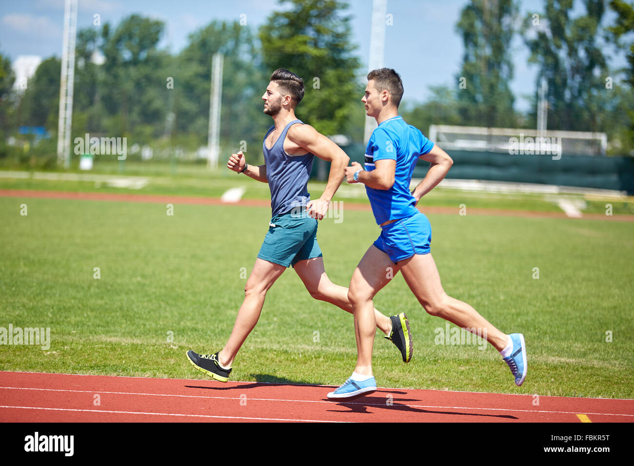 Two athletes friends running on a stadium track Stock Photo - Alamy